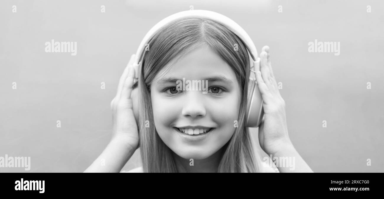 Portrait of school girl with smiling face listening to music in ...
