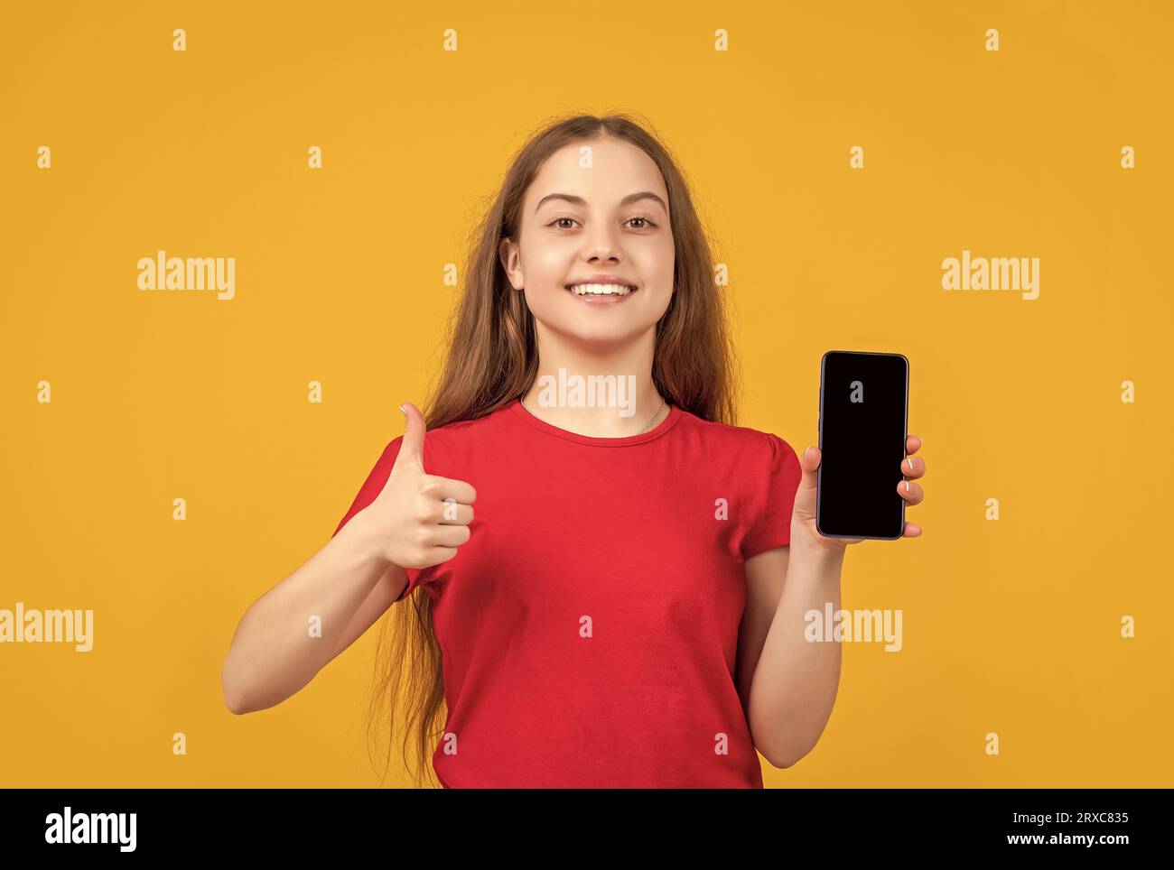 positive child with smartphone on yellow background Stock Photo - Alamy