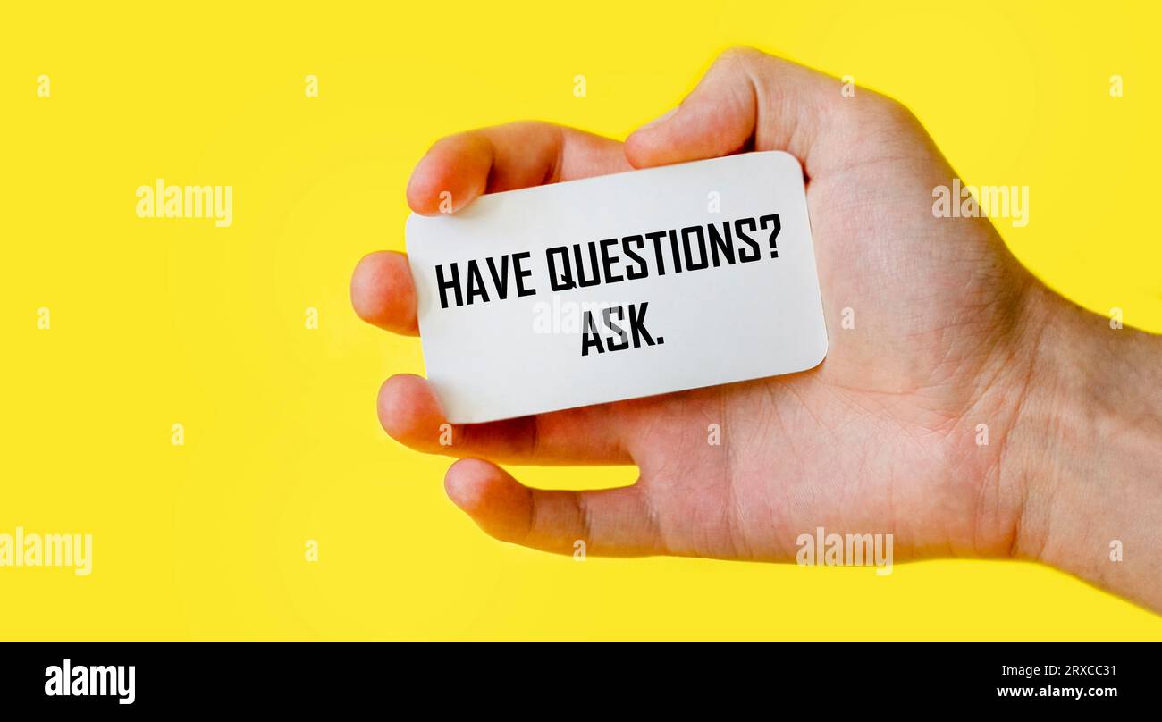 Have questions Ask. Man holding card on yellow background Stock Photo ...