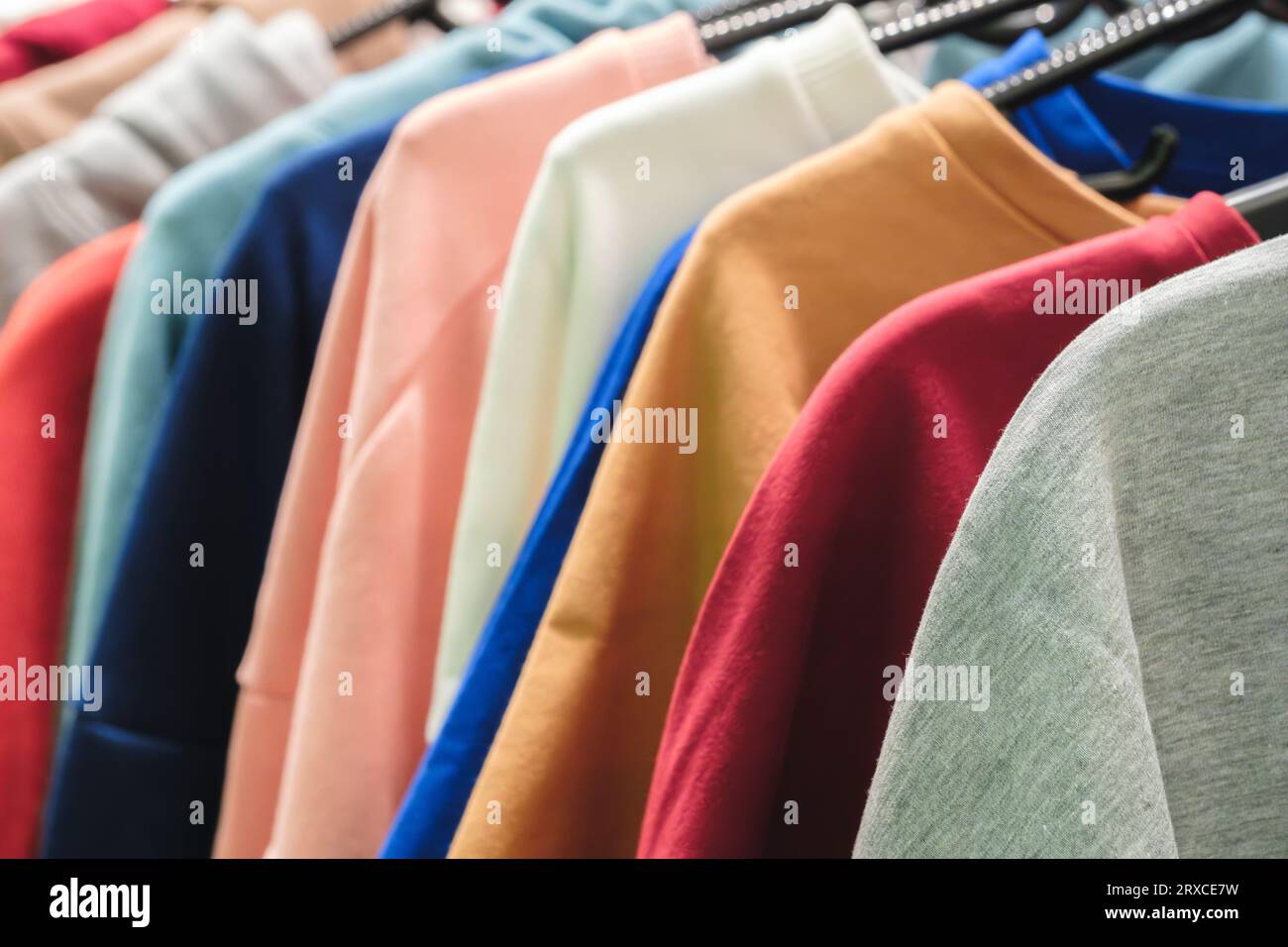 Fashion hoodie clothes on clothing rack Closeup of rainbow color choice ...