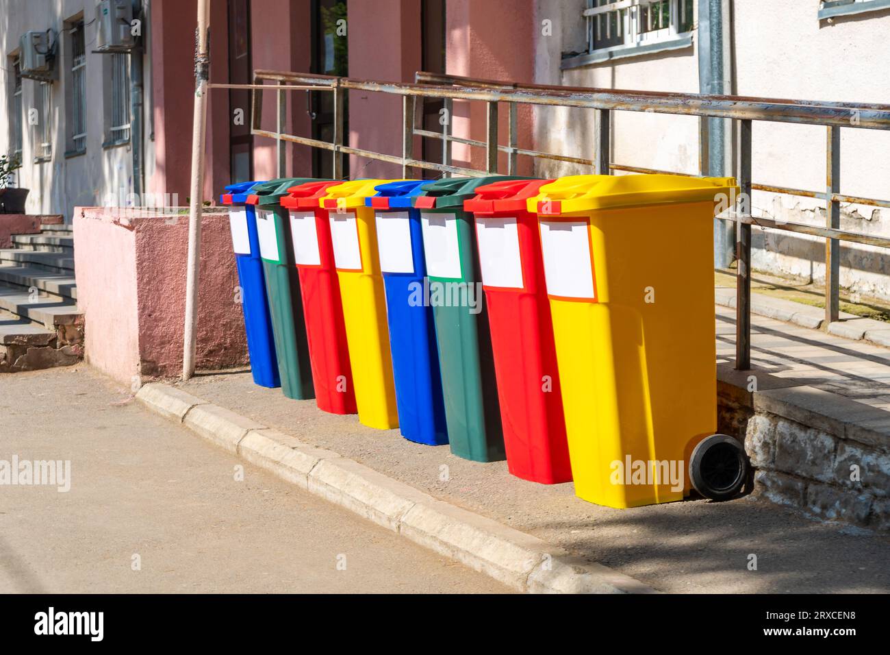 Garbage trash bins multicolor red, yellow, green, blue in school yard ...