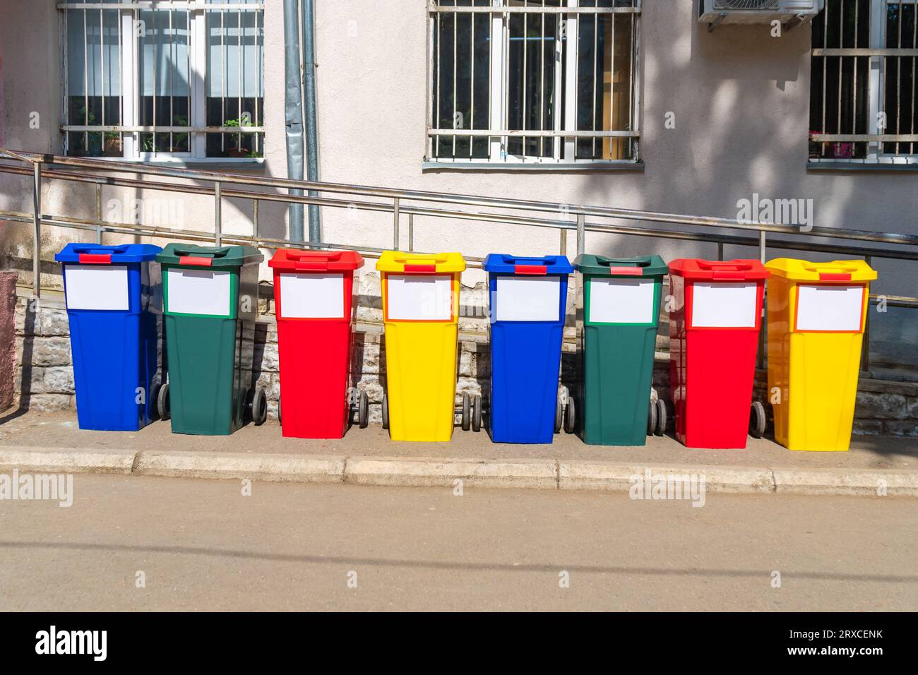 Garbage trash bins multicolor red, yellow, green, blue in school yard ...