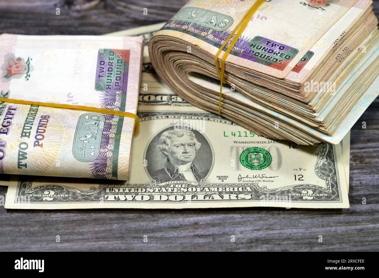 Folded Egyptian money 200 LE and pile of American money isolated on ...