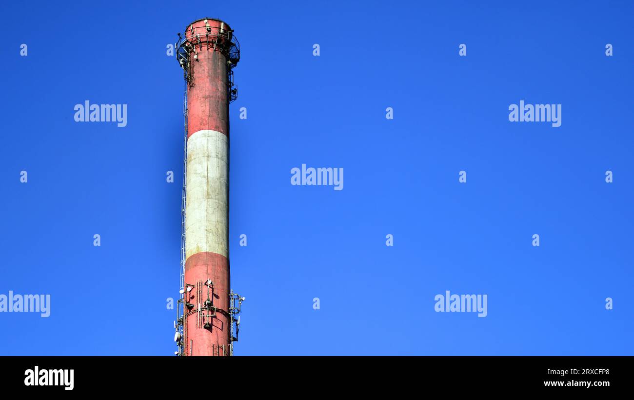 Tall industrial chimney isolated on blue sky background Stock Photo - Alamy