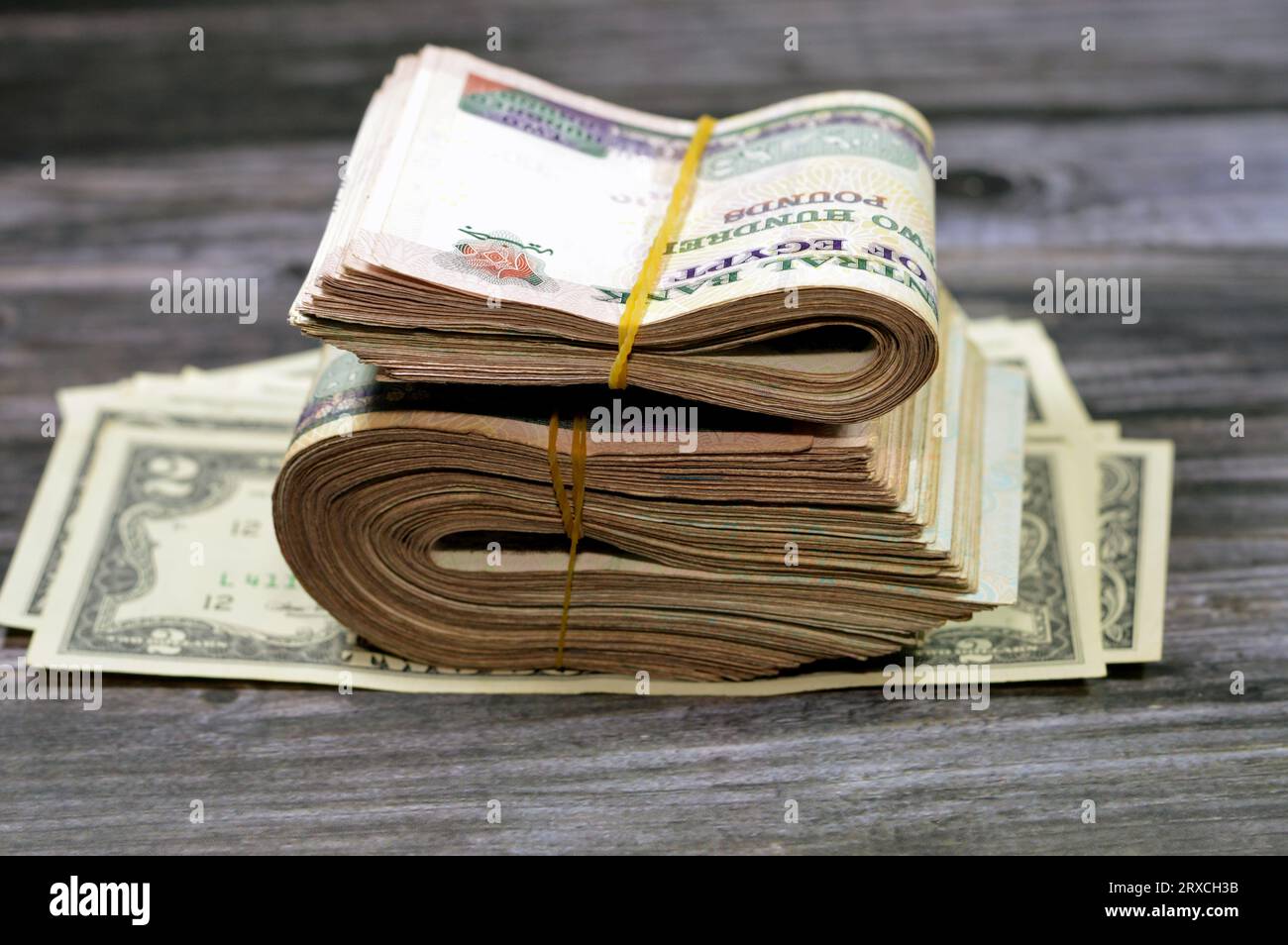 Folded Egyptian money 200 LE and pile of American money isolated on ...