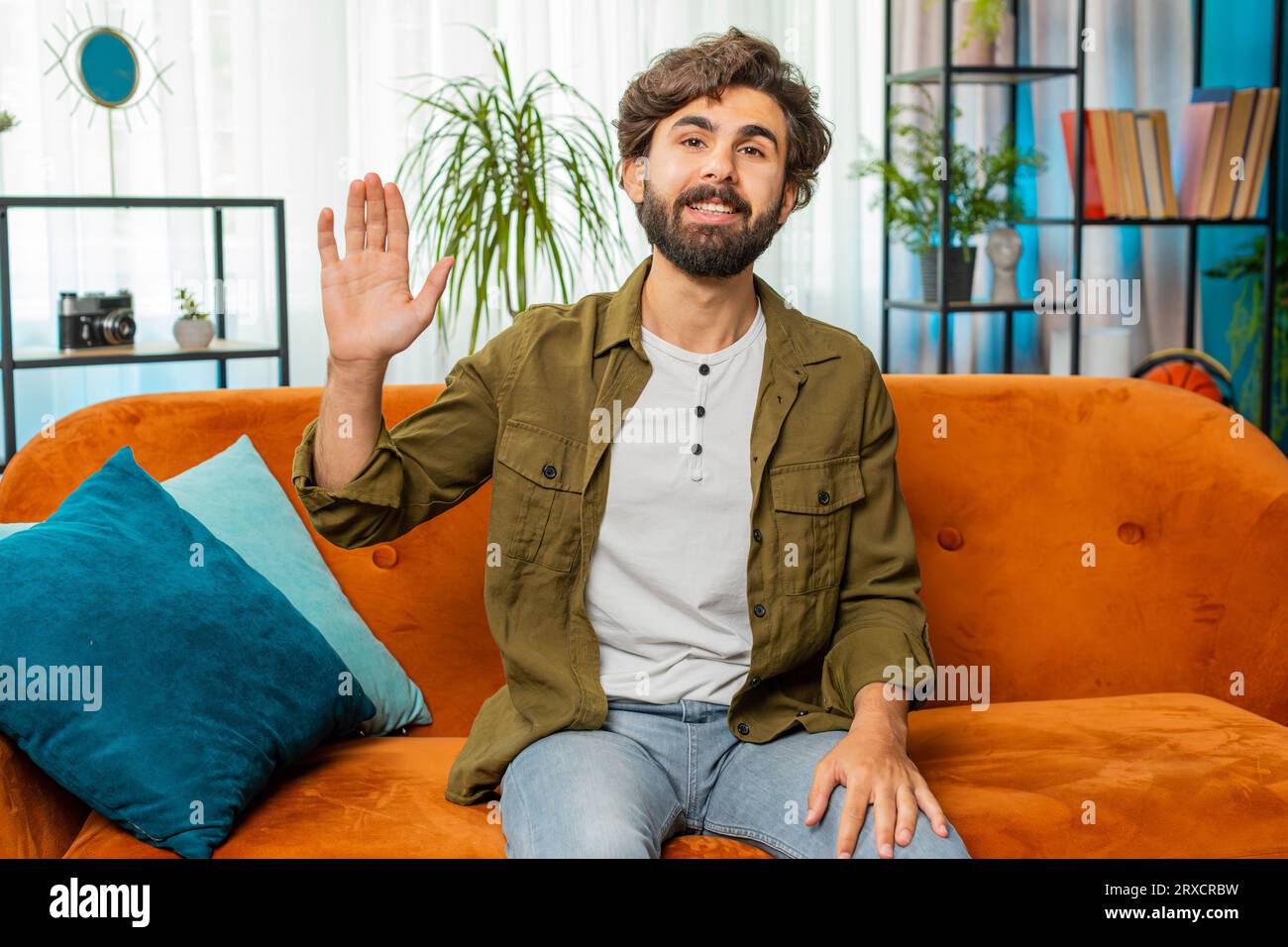 Hello. Middle eastern handsome man smiling friendly at camera and ...