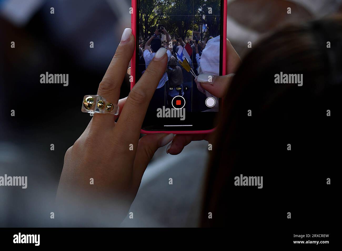 A woman films the event with her cell phone. Thousands of people came ...