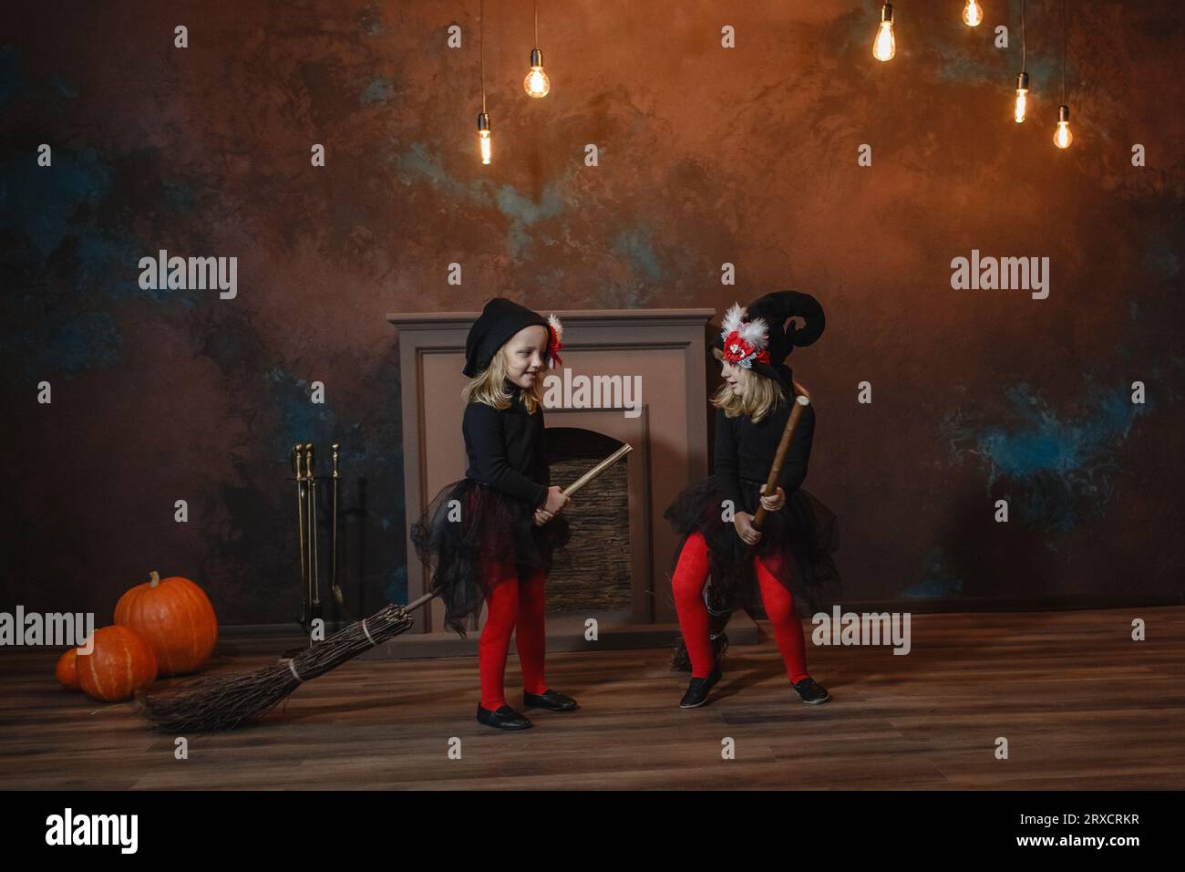 The little witches sit on their brooms, about to fly away through the ...