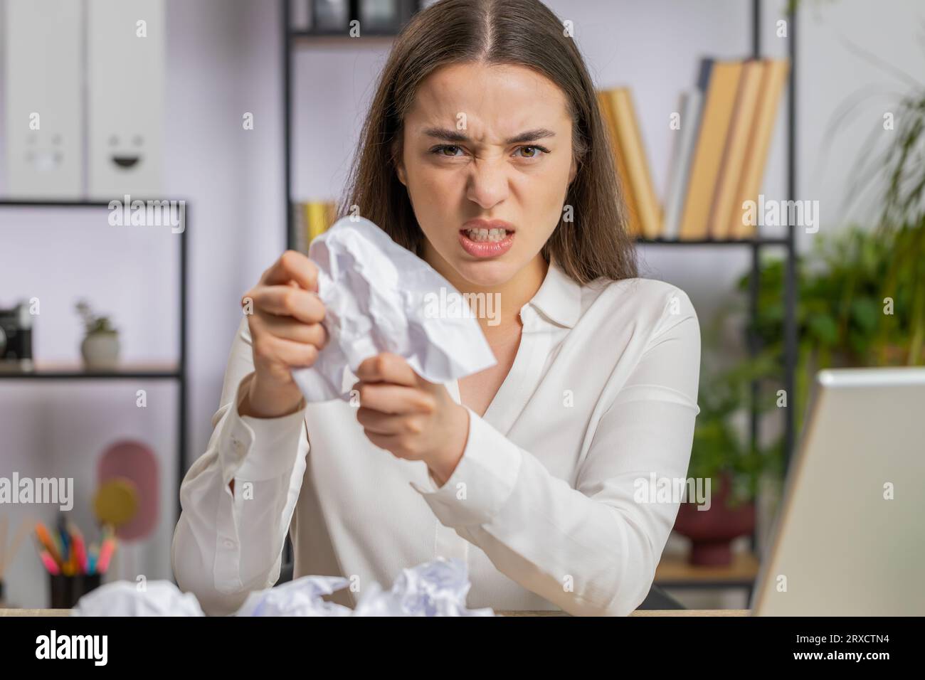 Angry furious business woman working at office throwing crumpled paper ...