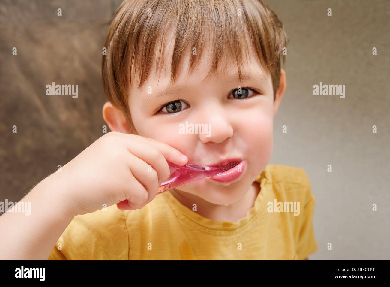 Close up portrait of a cute little baby brushing his teeth with a ...