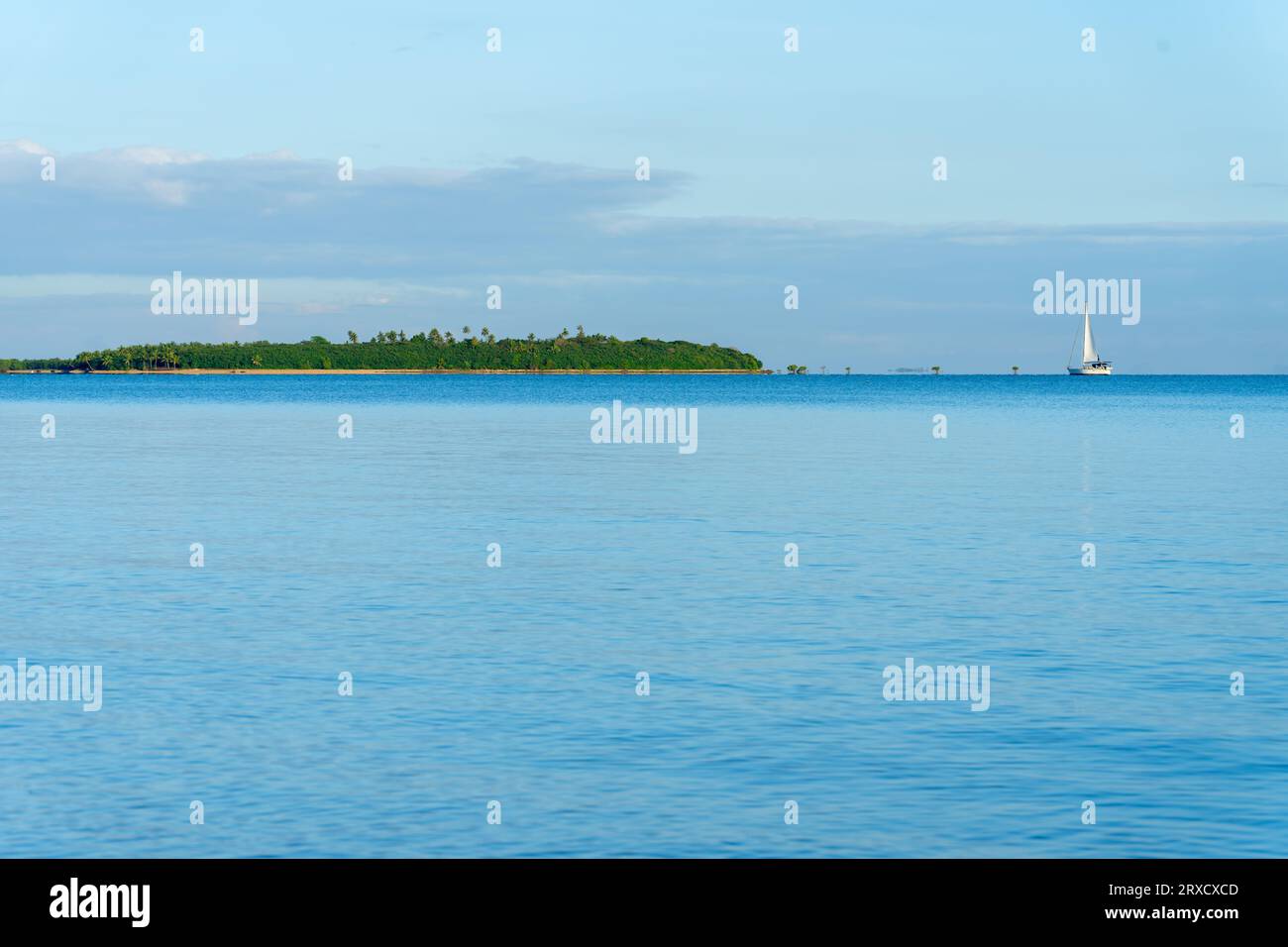 Distant small yacht under sail way off on horizon sailing toward small ...