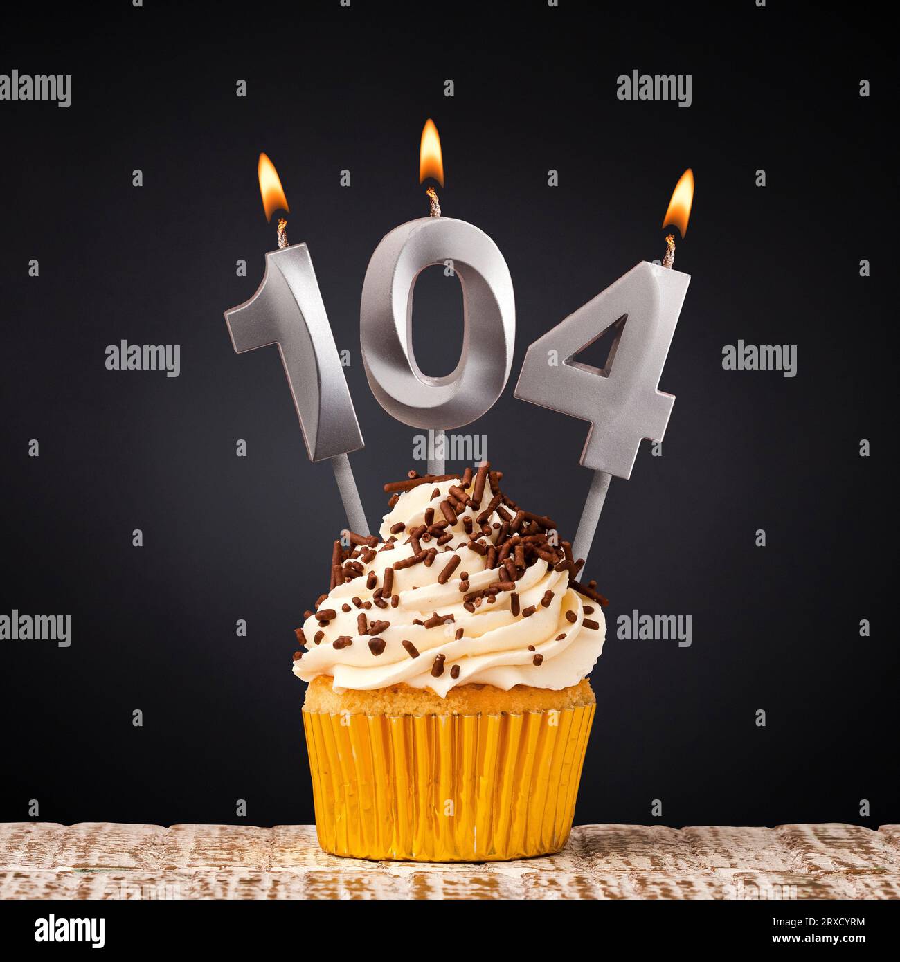 birthday cupcake with number 104 candle - Celebration on dark ...