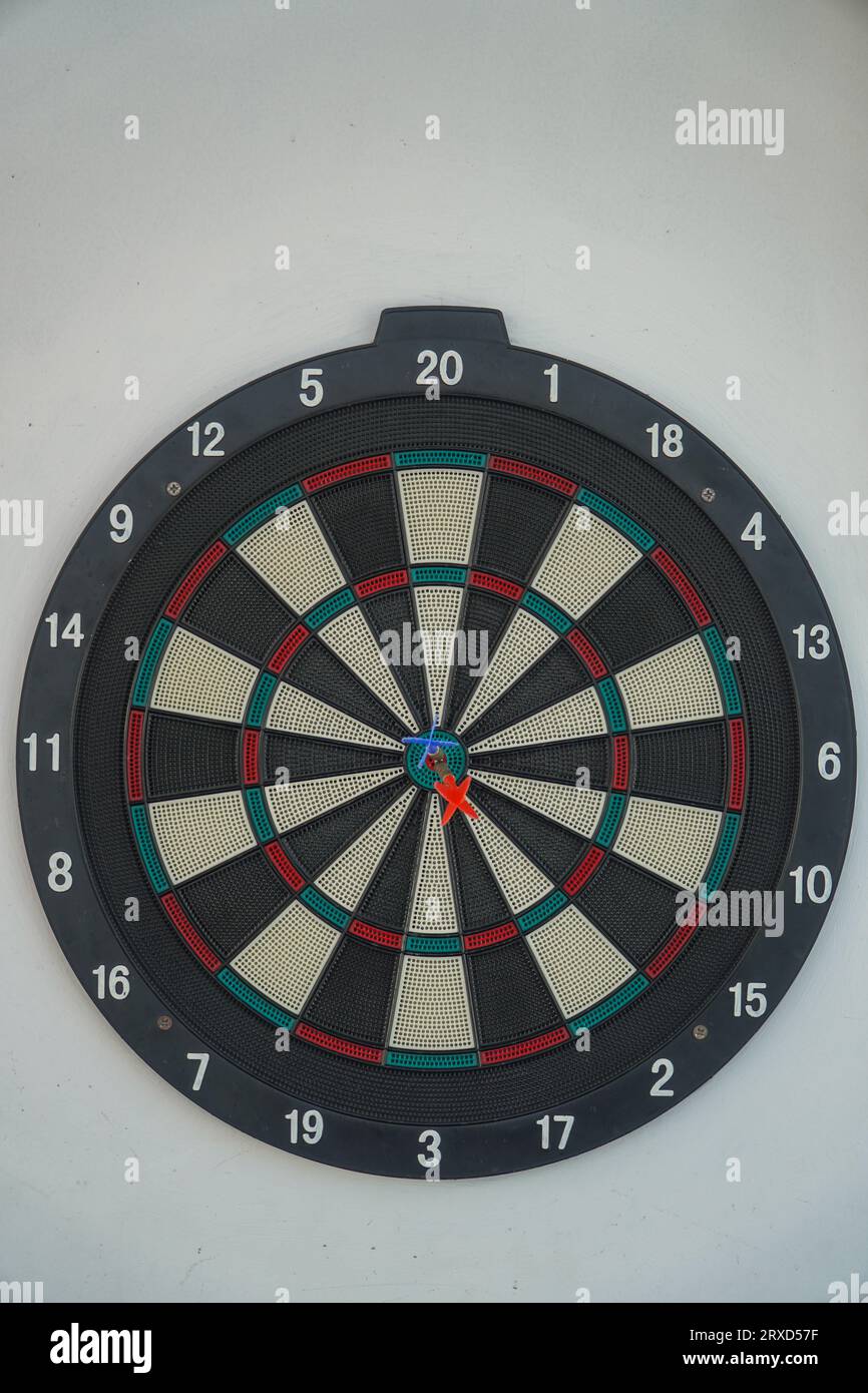Dart board on white wall background. The dart hit the center of the ...