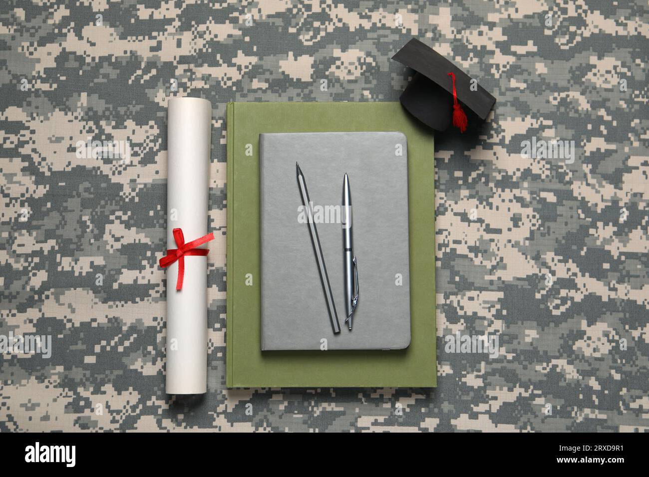 Stationery, diploma and mortarboard on camouflage background, flat lay ...