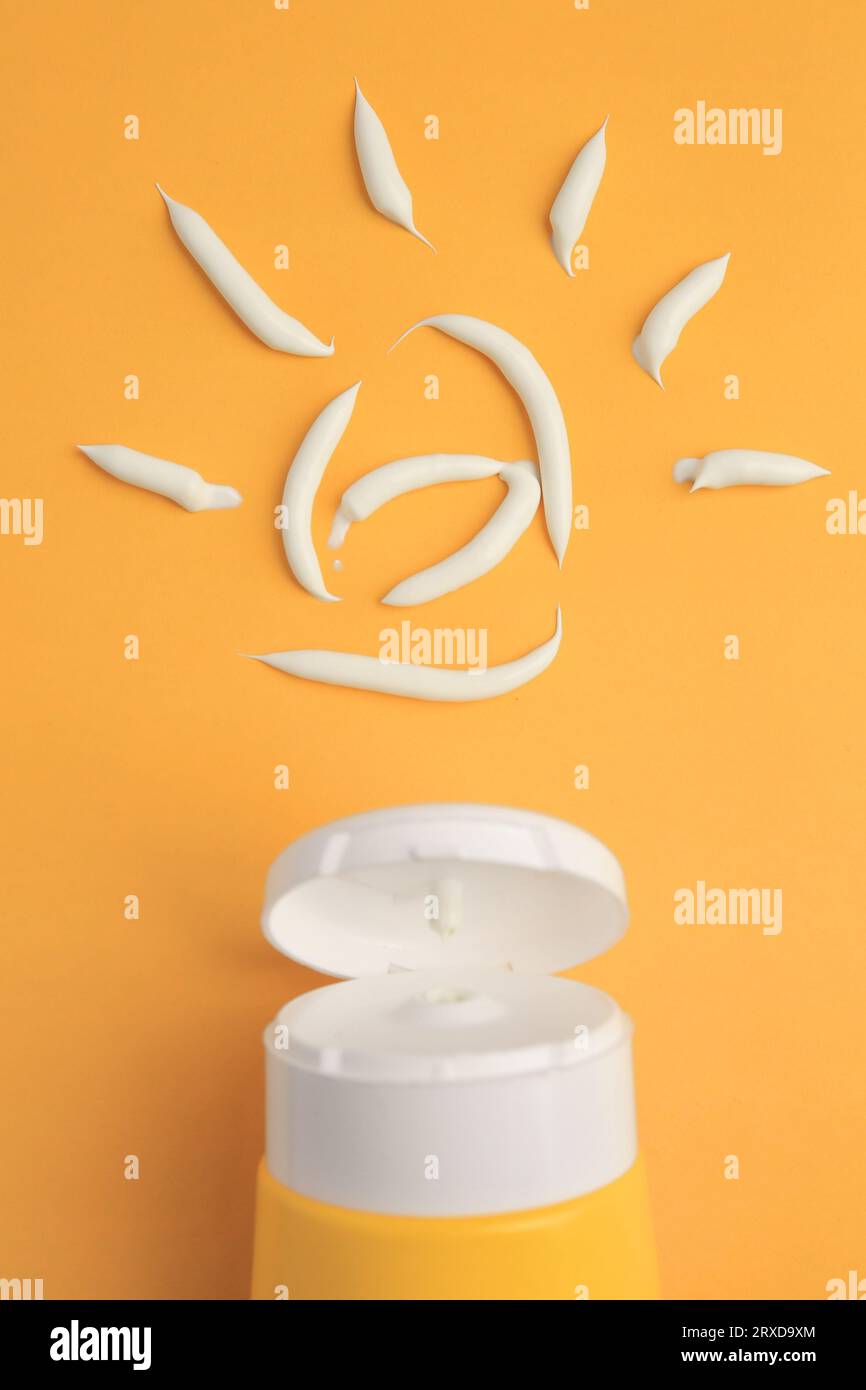 Drawing of sun and tube with sunscreen on orange background, above view ...