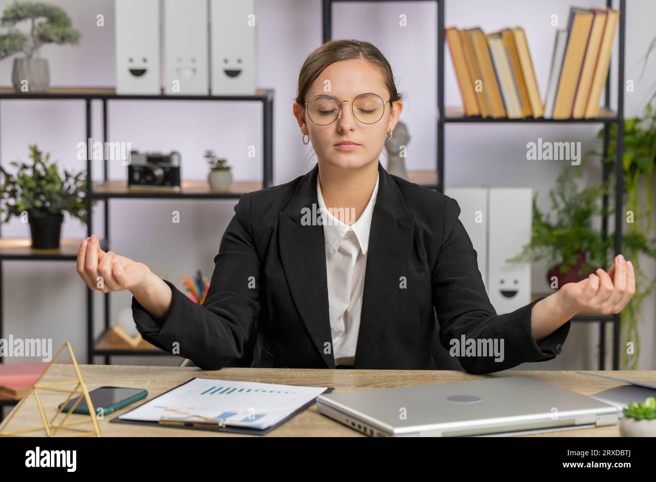Caucasian business woman working on laptop computer, meditating doing ...