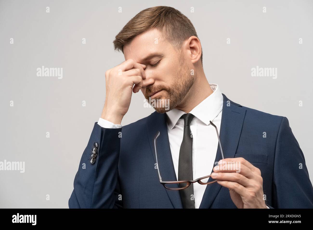 Businessman takes off glasses, massaging eyelids of eyes. Overworked ...