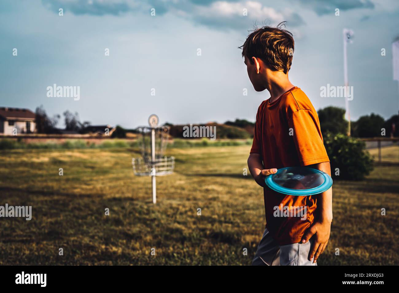 Young Caucasian male boy aiming a disc golf at a chain goal Stock Photo ...