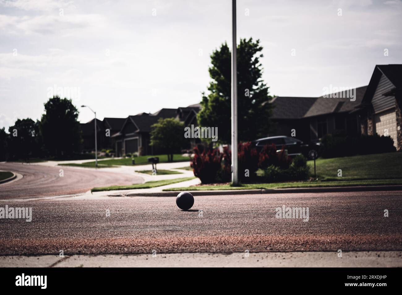 Chasing a ball that has crossed the street by rolling into a road Stock ...