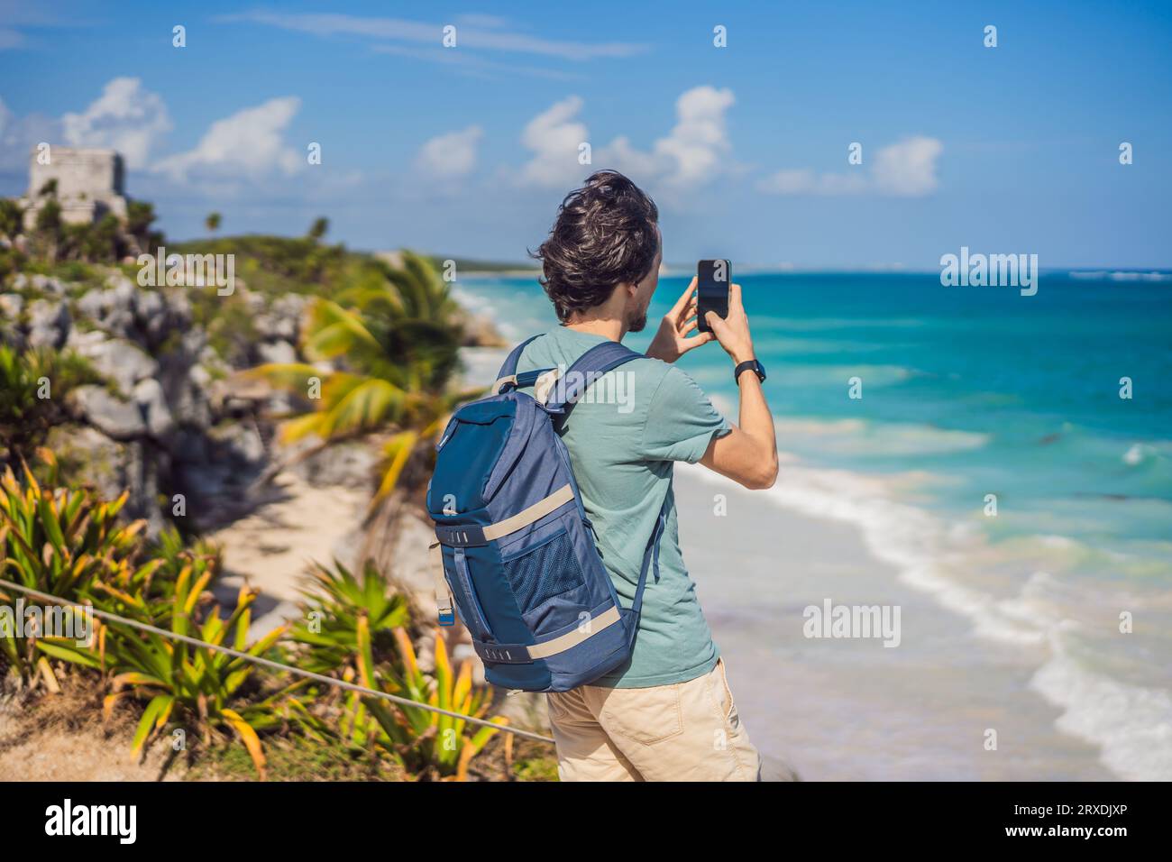 Male tourist enjoying the view Pre-Columbian Mayan walled city of Tulum ...