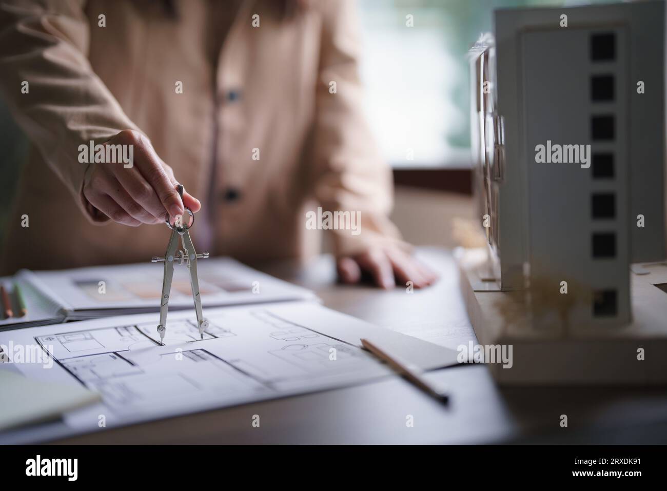 Female architect using divider compass to drawing building project and ...