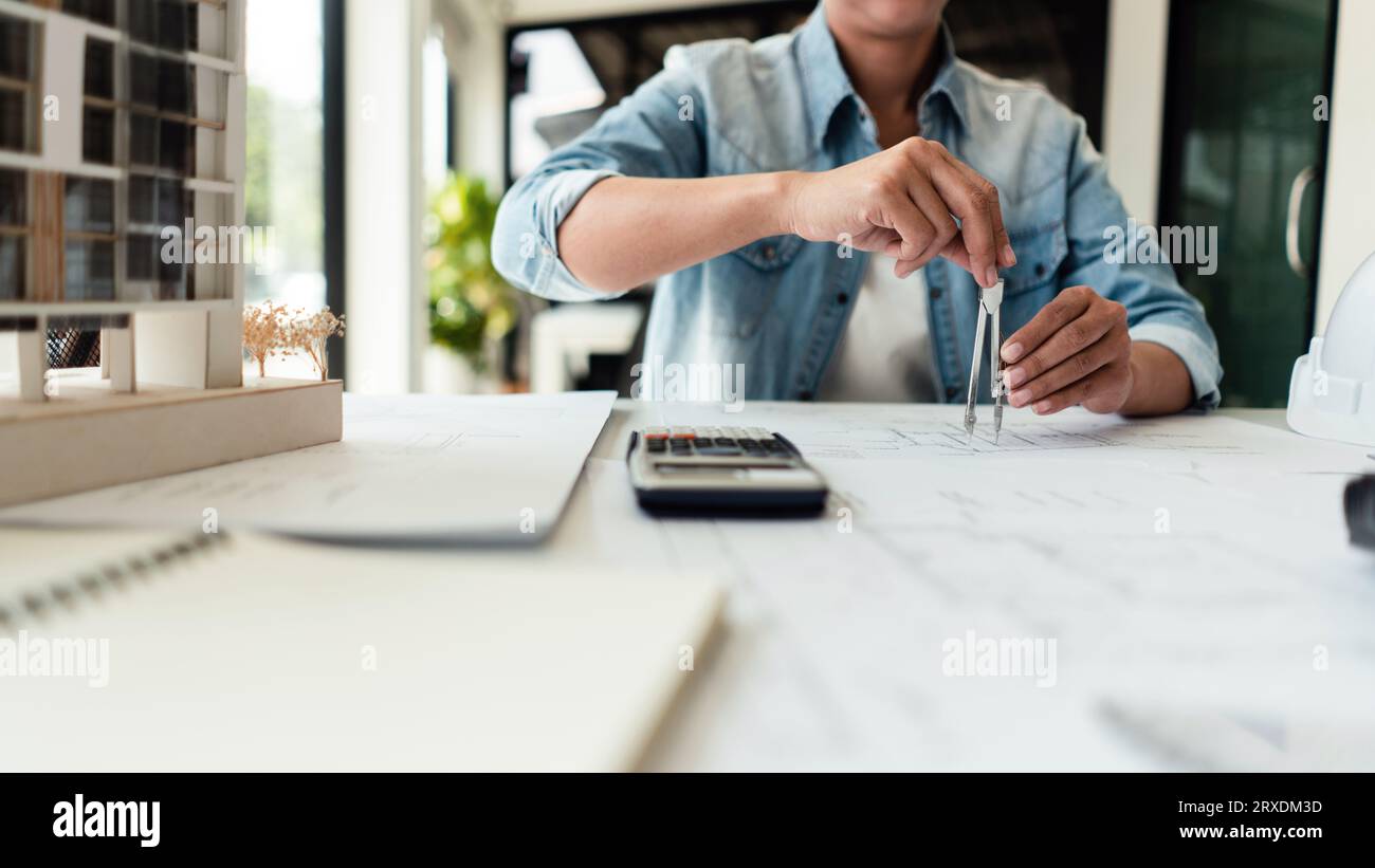 Female engineer use geometry compass and working to drawing ...