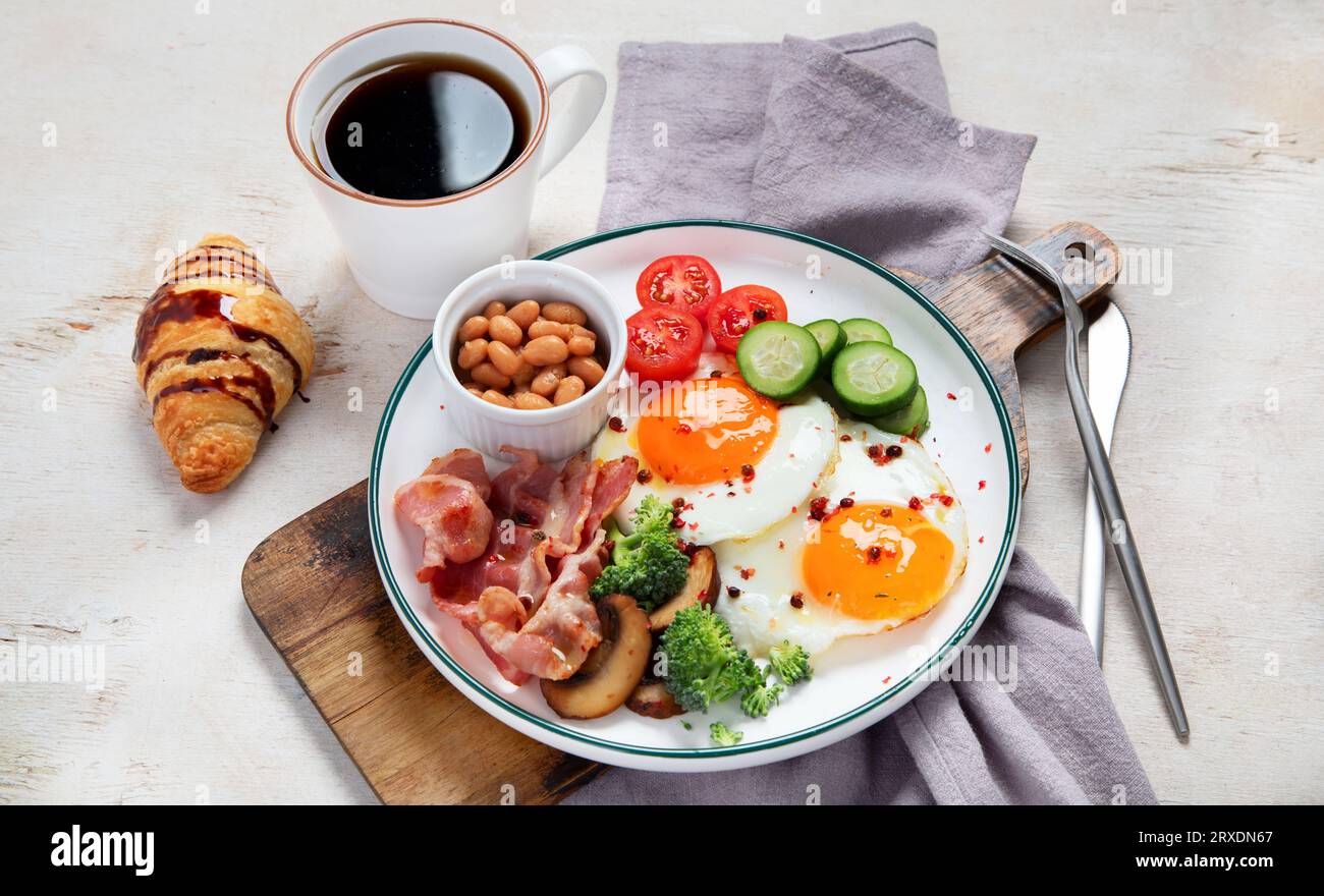 Traditional Englis breakfast plate with bacon strips, sunny side up ...