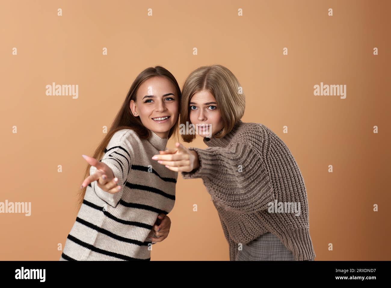 Two cheerful attractive women friends talking together Stock Photo - Alamy