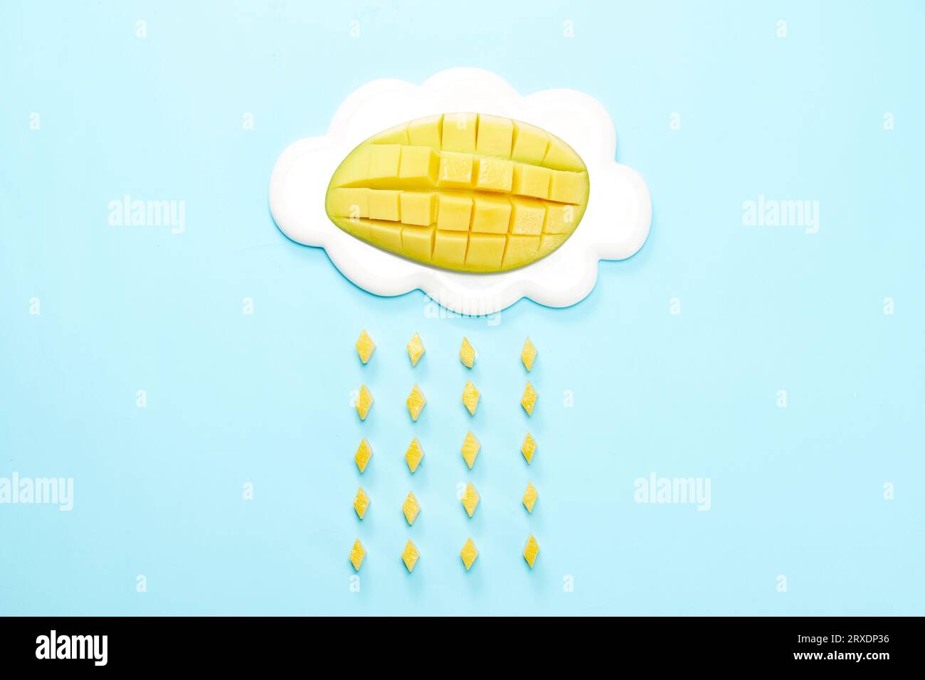 half fresh mango diced in classic cubes close-up isolated on blue ...