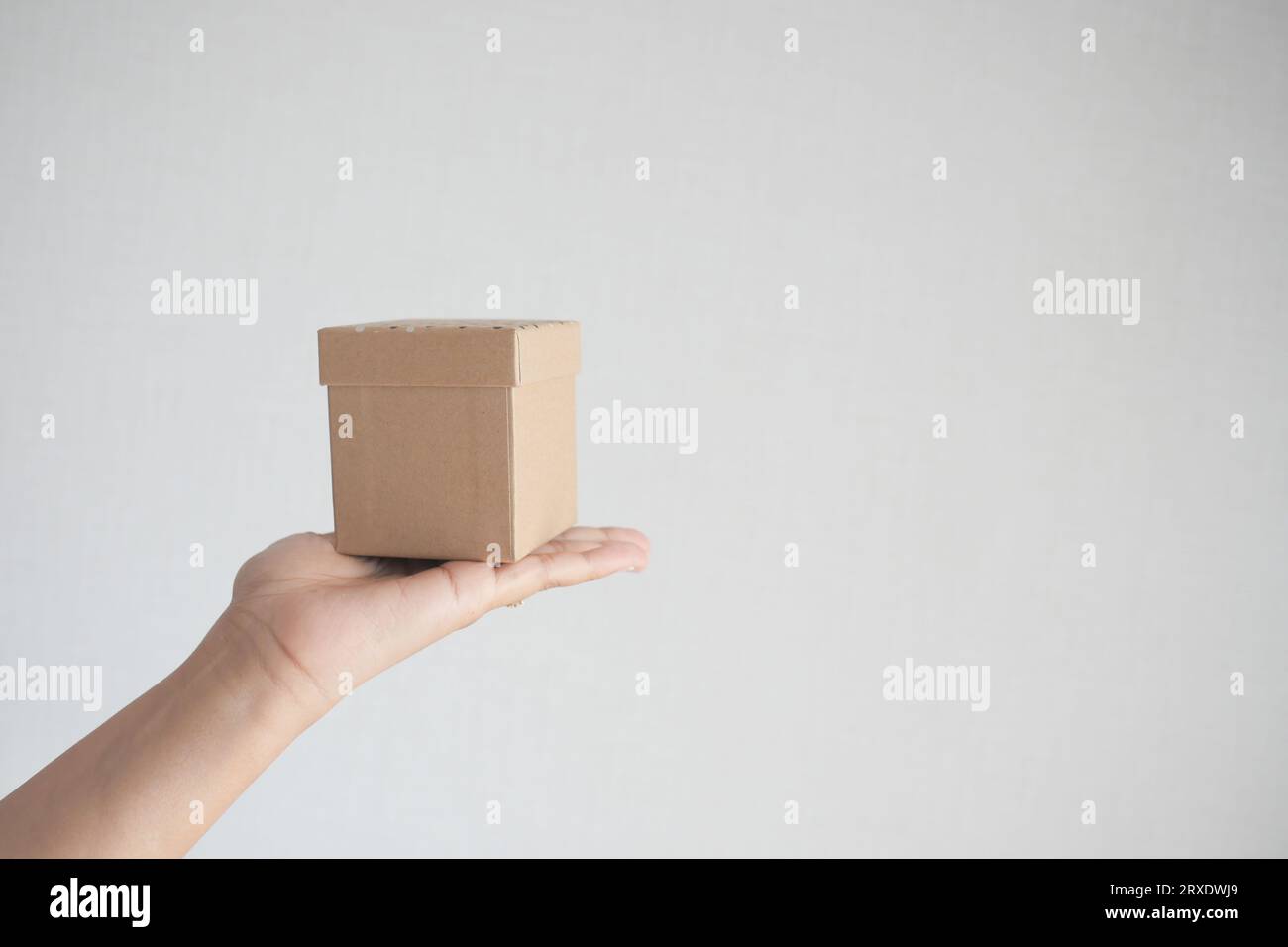hand hold homemade gift box against white background Stock Photo - Alamy