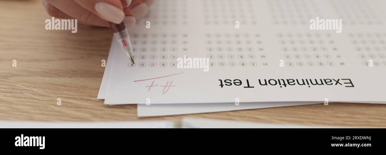 Hand with pen on examination test paper with excellent mark close up ...