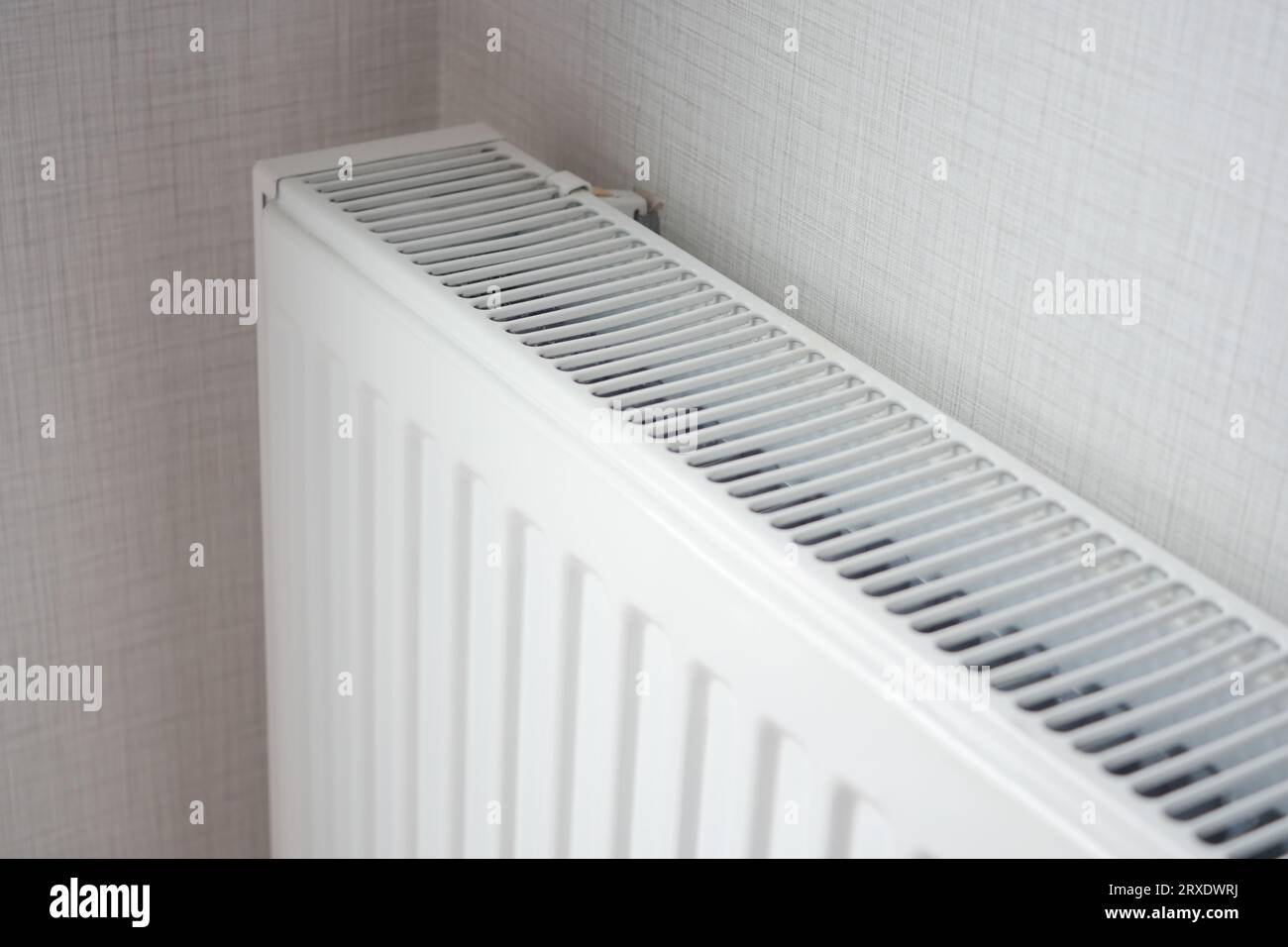 White radiator on grey white wall. apartment heating installation ...