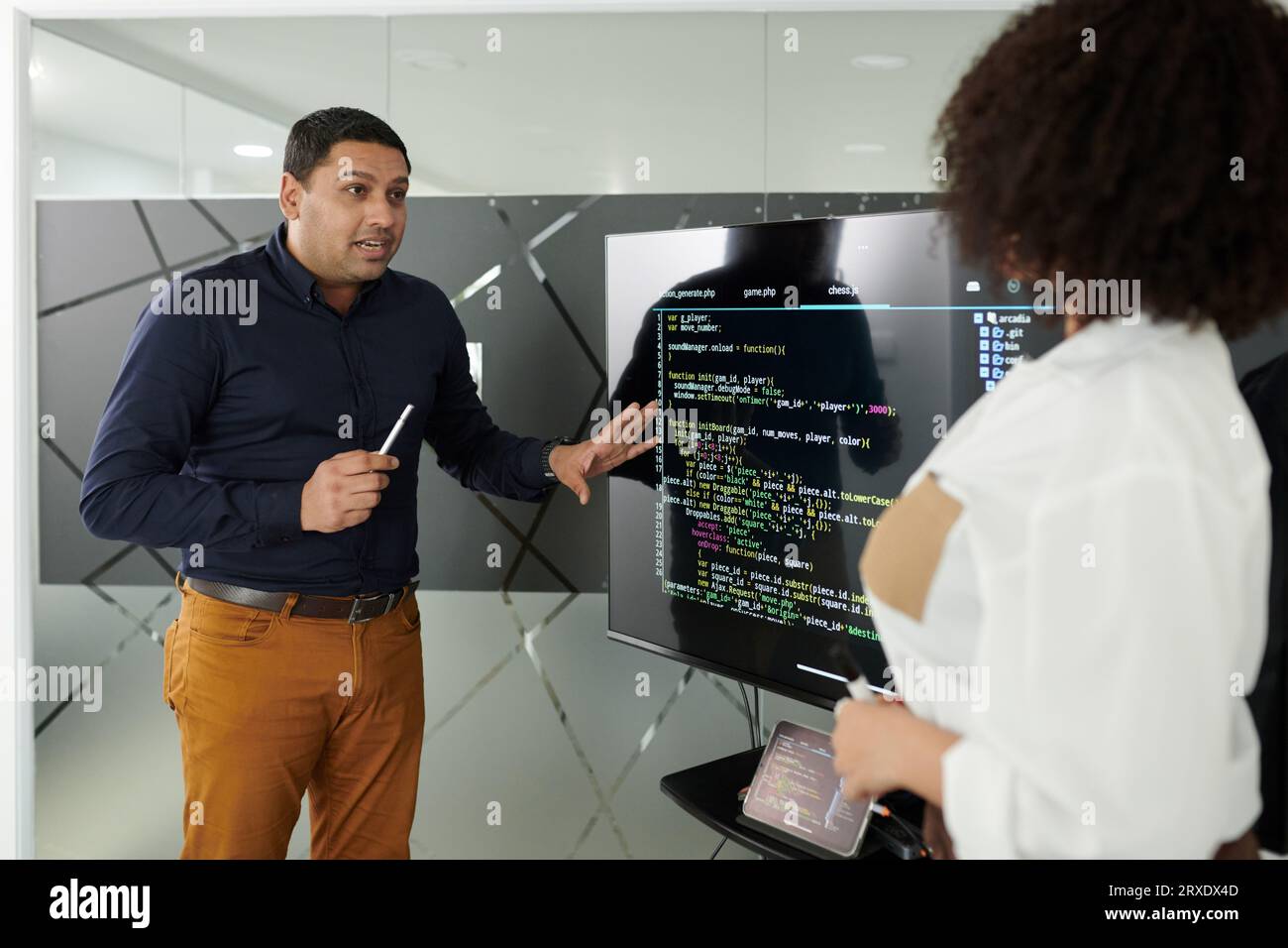 Emotional team leader discussing bugs in programming code with developer Stock Photo - Alamy