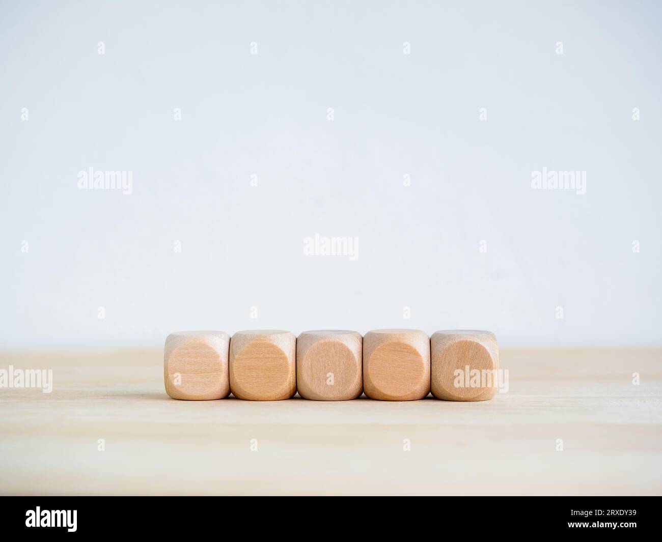Five empty small wooden cube blocks arranged as a horizontal row on ...