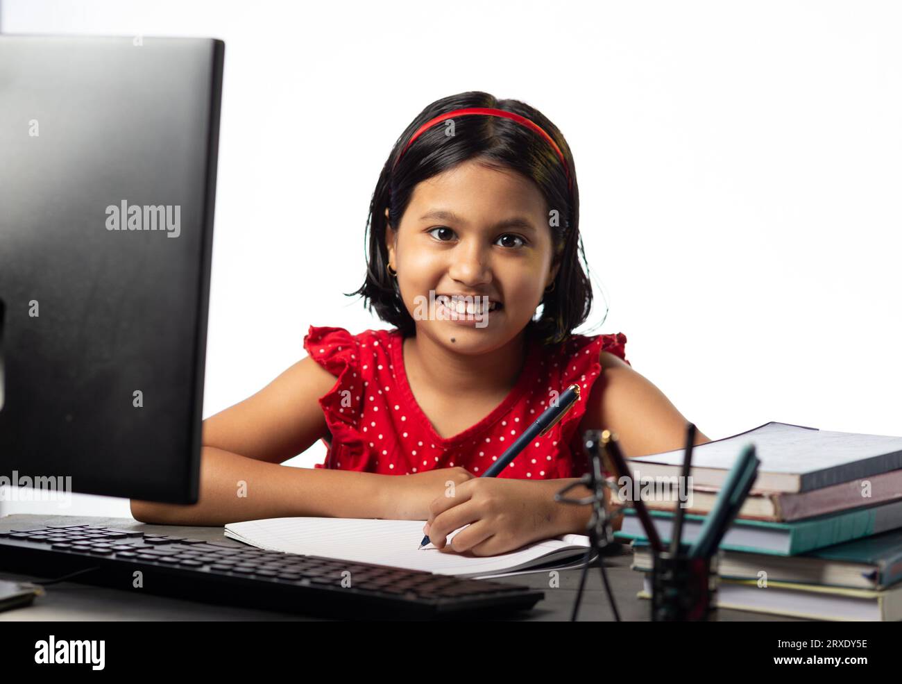 A pretty beautiful Indian girl child studying with desktop computer at ...
