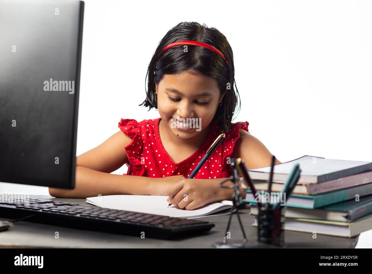 A pretty beautiful Indian girl child studying with desktop computer at ...