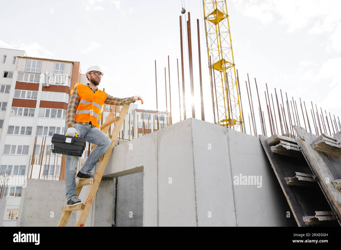 Maintenance worker man with safety helmet and orange vest climbing wood ...