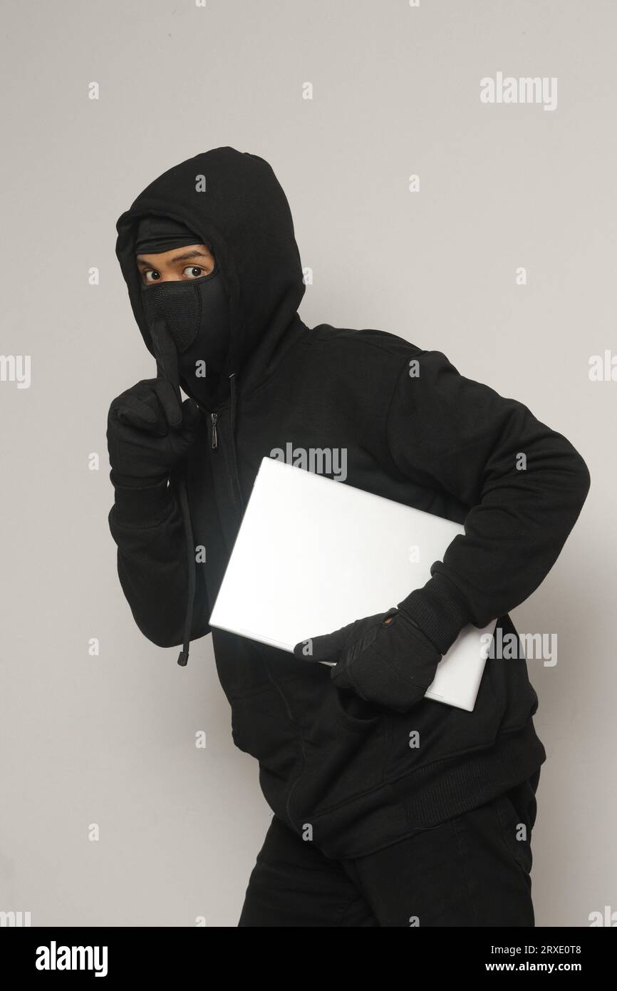 Mysterious robber thief man wearing black hoodie and mask stealing ...