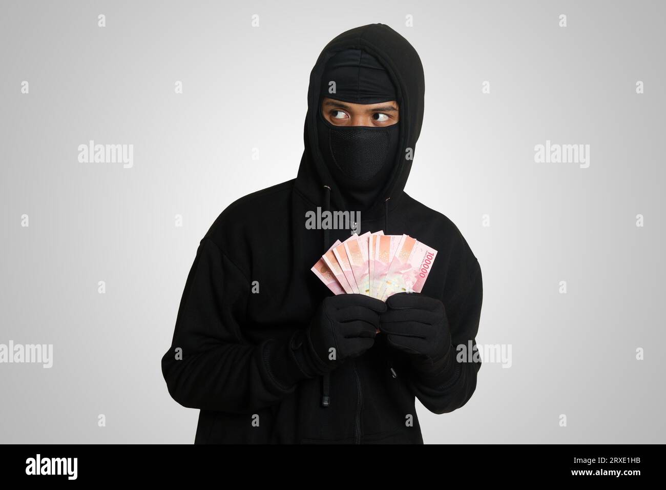 Portrait of mysterious man wearing black hoodie and mask stealing one ...