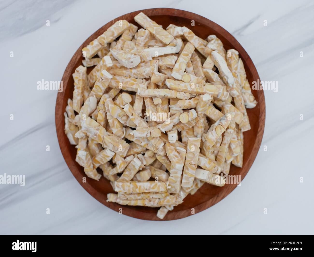 raw tempeh or tempe. Orek tempeh on a wooden plate. tempeh made from ...