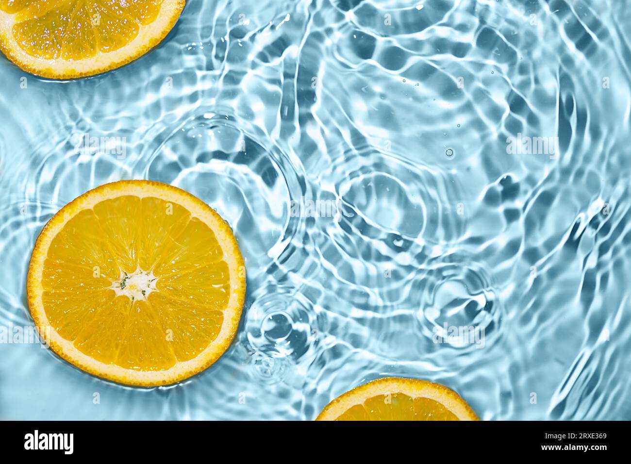 Creative summer background with orange fruit slices in swimming pool ...