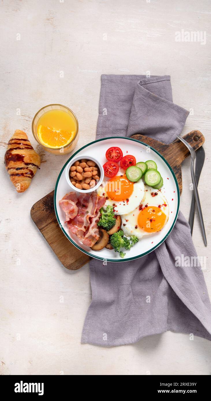 Traditional Englis breakfast plate with bacon strips, sunny side up ...
