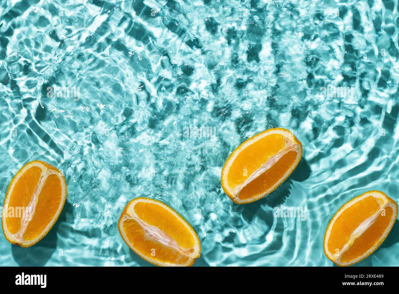 Creative summer background with orange fruit slices in swimming pool ...