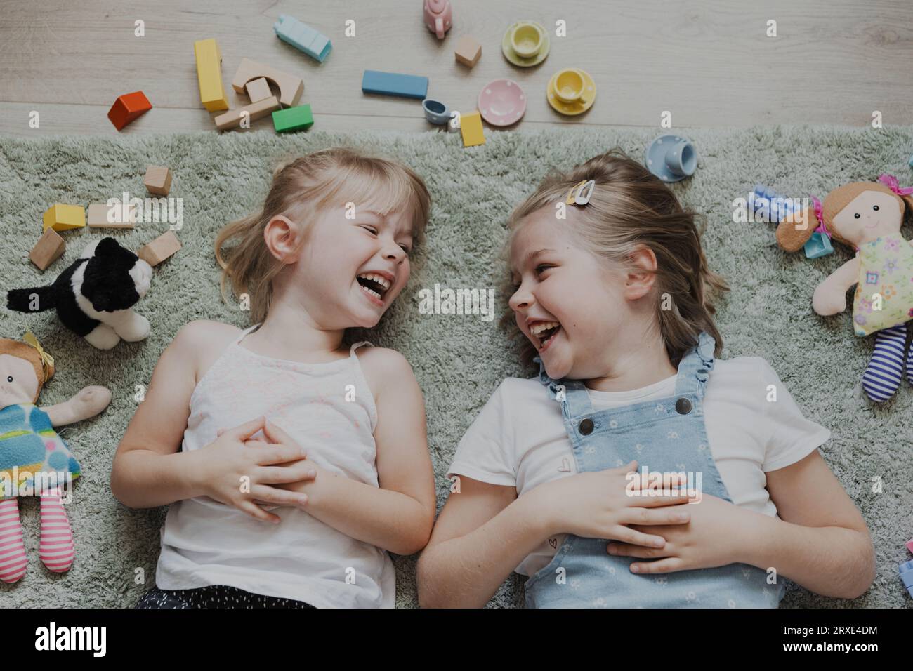 Top view from above on children playing with colorful toys. Portrait of ...