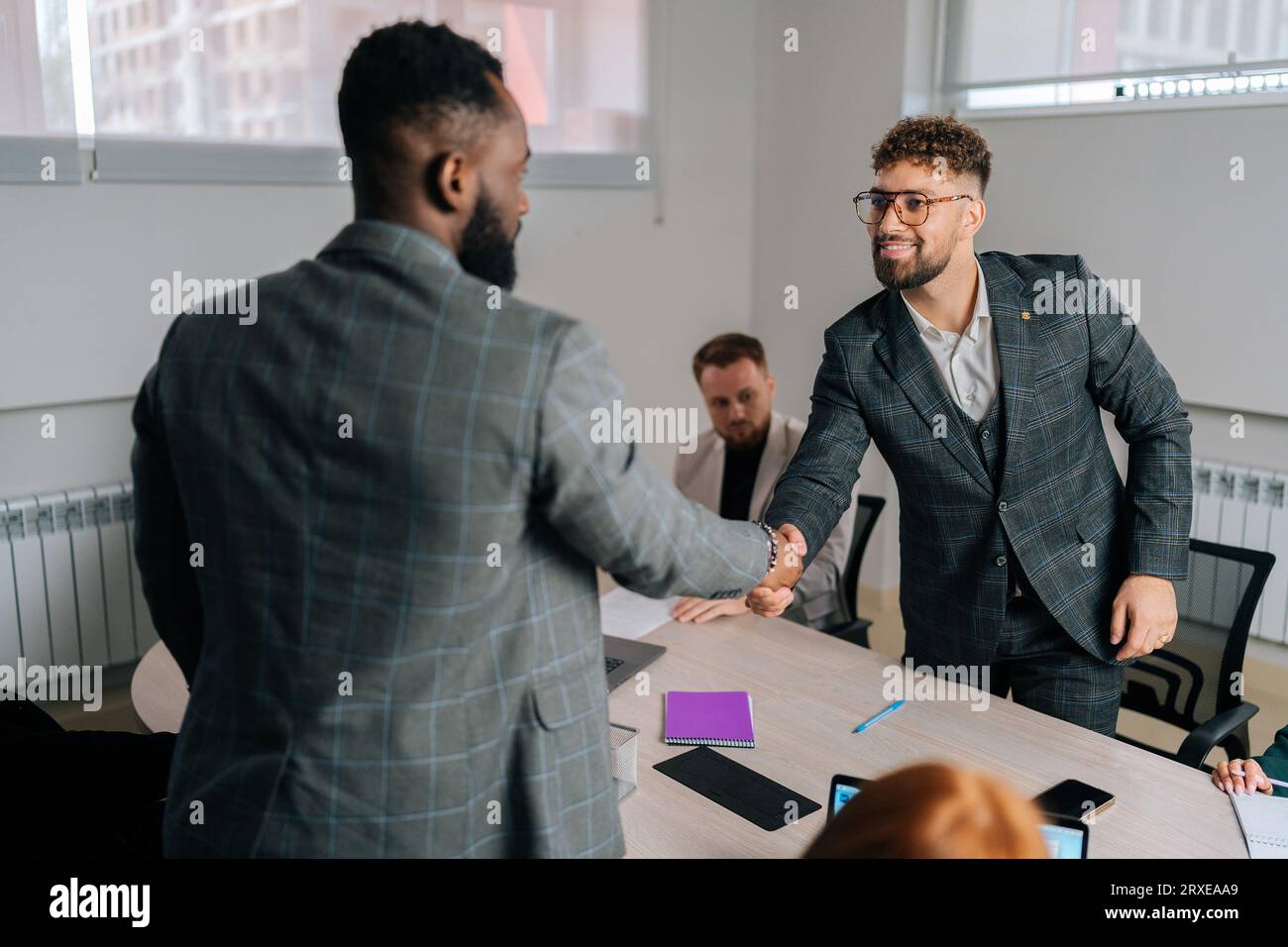 Rear view of handshaking for happy African businessman and Caucasian ...