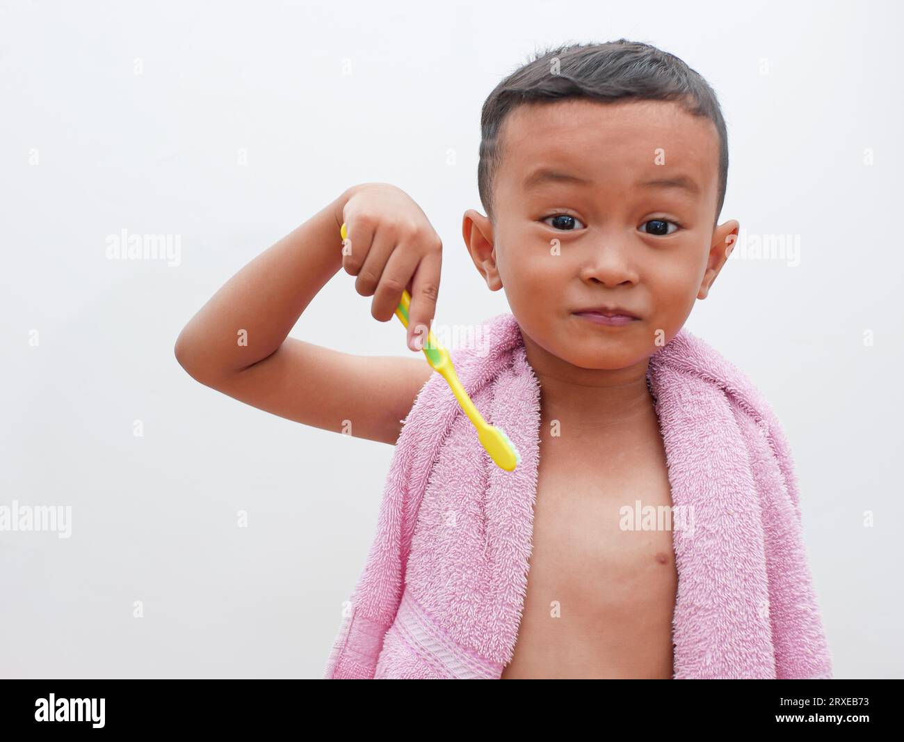 little asian boy holding a toothbrush on white background with copy ...