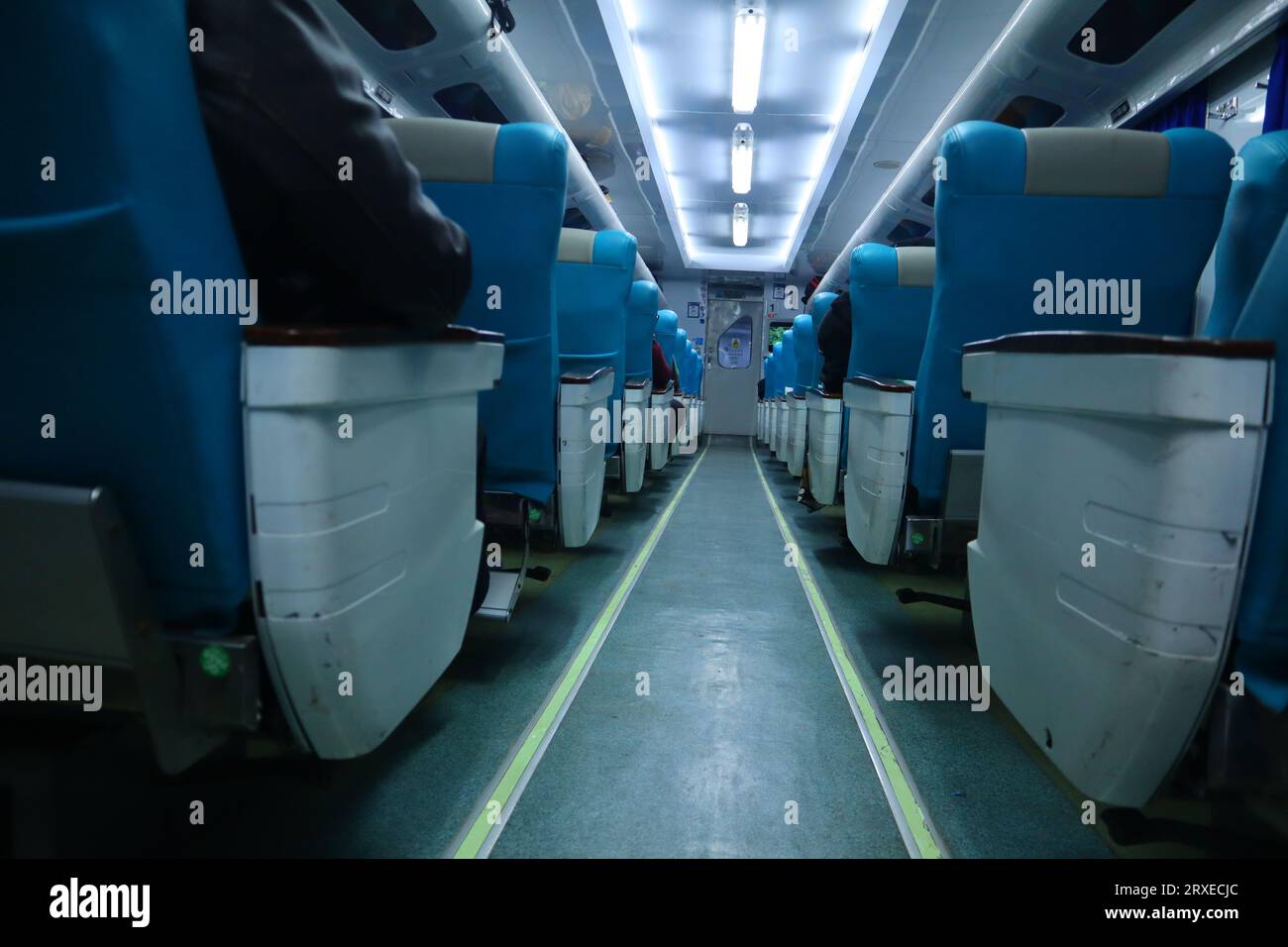 Executive class train interior with blue seats, armrests, luggage racks ...