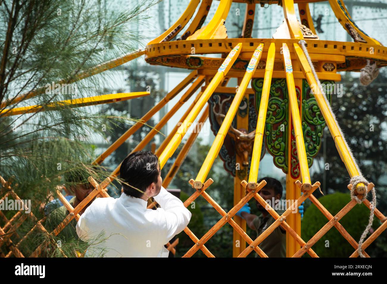 Men assembling the wooden frame of a Mongolian yurt at Gardens by the ...