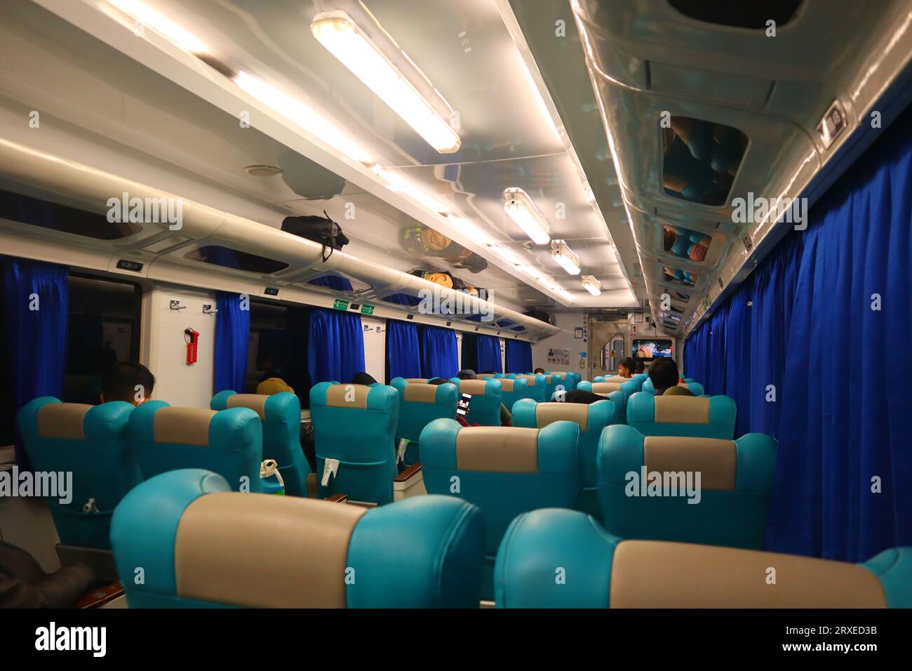 Executive class train interior with blue seats, armrests, luggage racks ...
