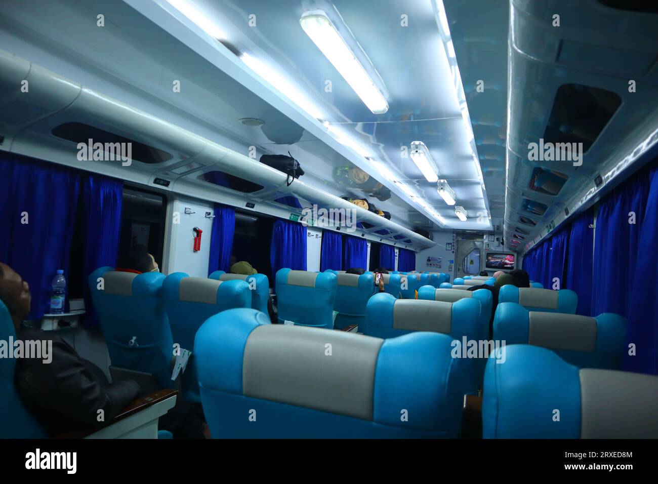 Executive class train interior with blue seats, armrests, luggage racks ...